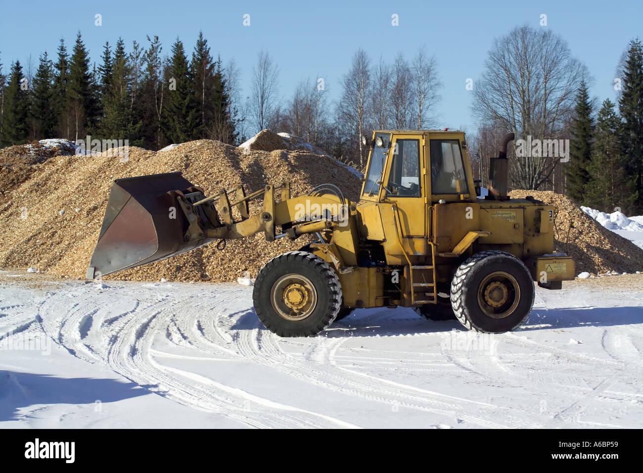 Front loader moving chopped wood Stock Photo - Alamy