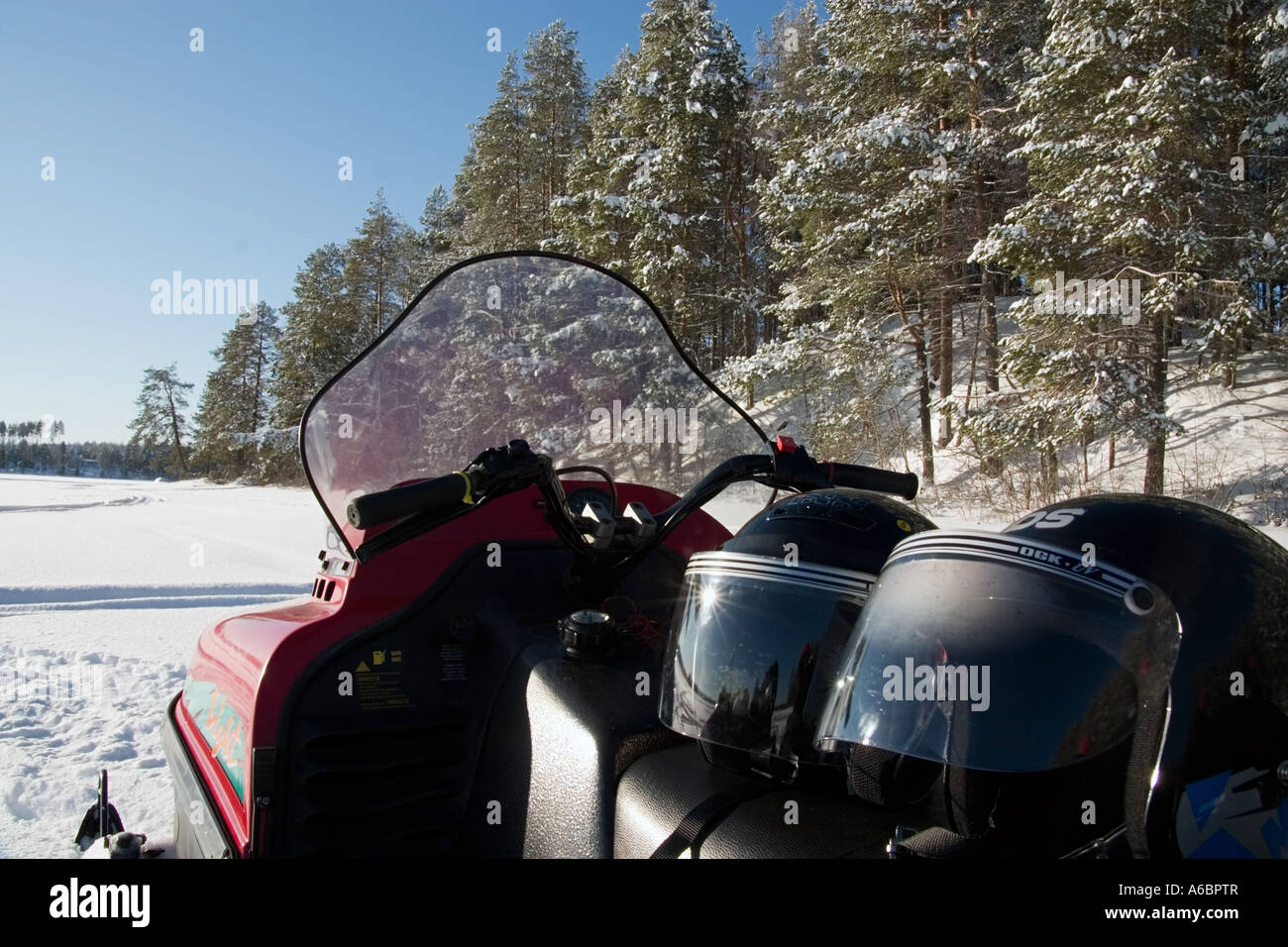 Two black crash helmets on the seat of a parked snowmobile Finland ...