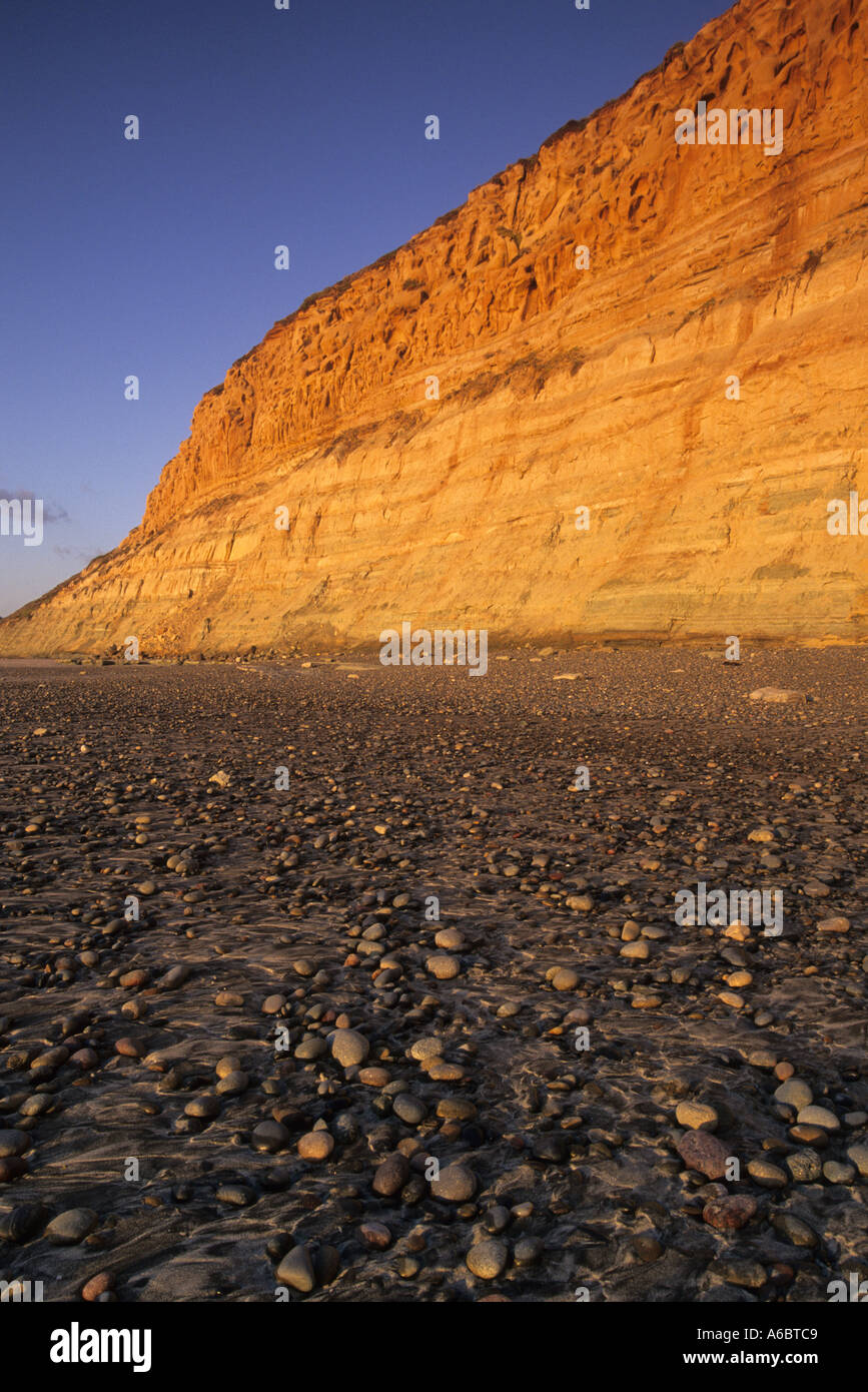 Sunset colors the cliffs along the beach at Torrey Pines State Reserve ...