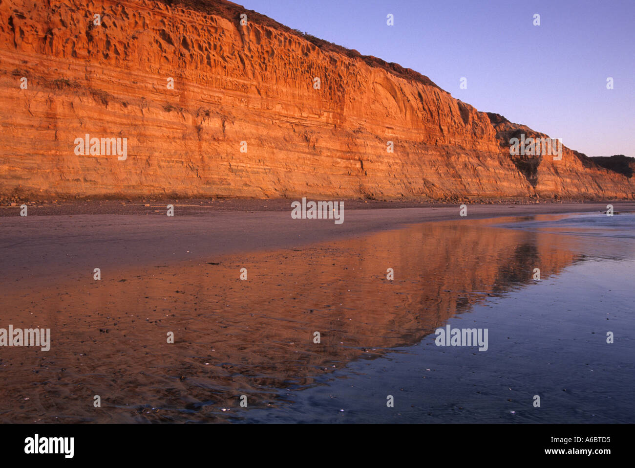 Sunset colors the cliffs along the beach at Torrey Pines State Reserve ...