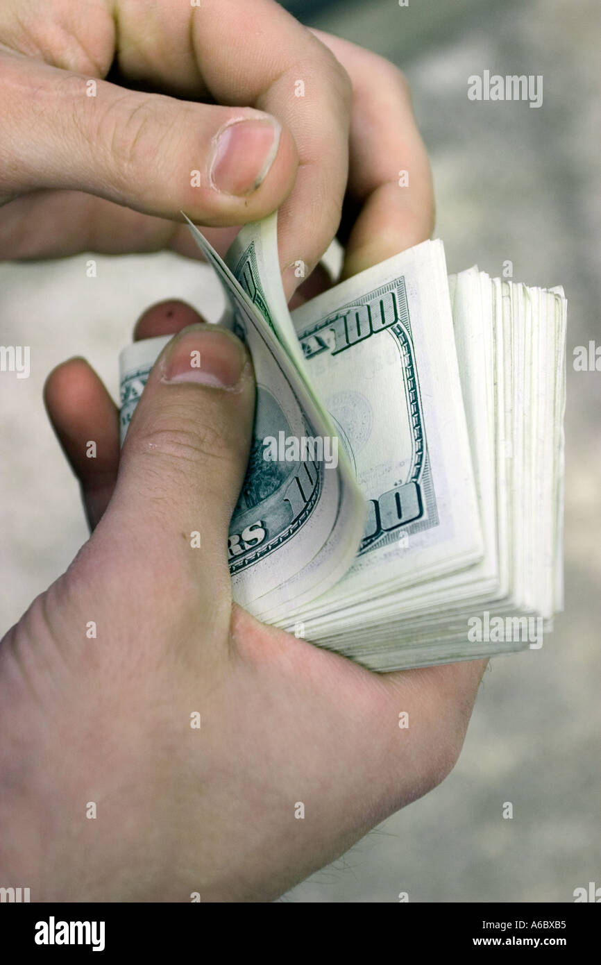 details of hand and fingers of man counting bundle of one hundred ...