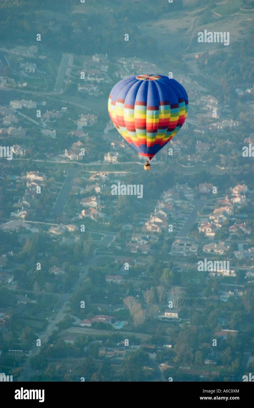 A single hot air balloon, seen from high above it, floats over a ...