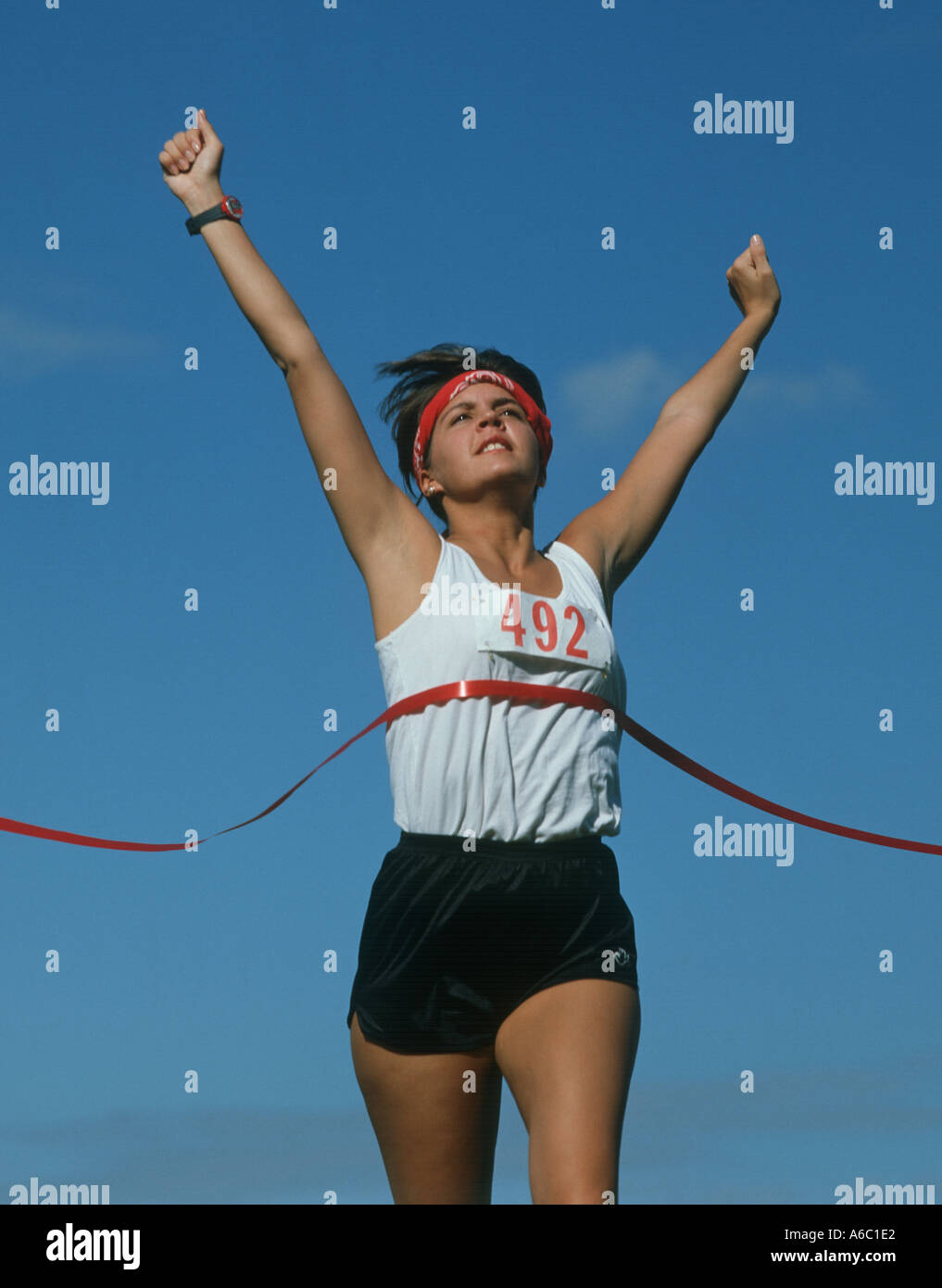 girl breaking the ribbon at a track meet as winner Stock Photo - Alamy