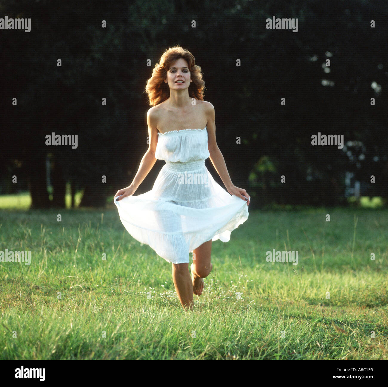 pretty girl running barefoot through the grass Stock Photo - Alamy