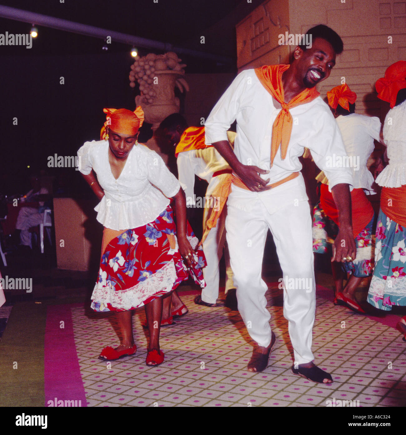 Local man in white and orange costume dancing with woman during ...