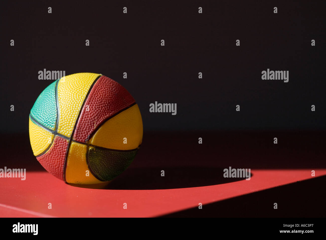 Colorful ball on red table with black shadow Stock Photo - Alamy