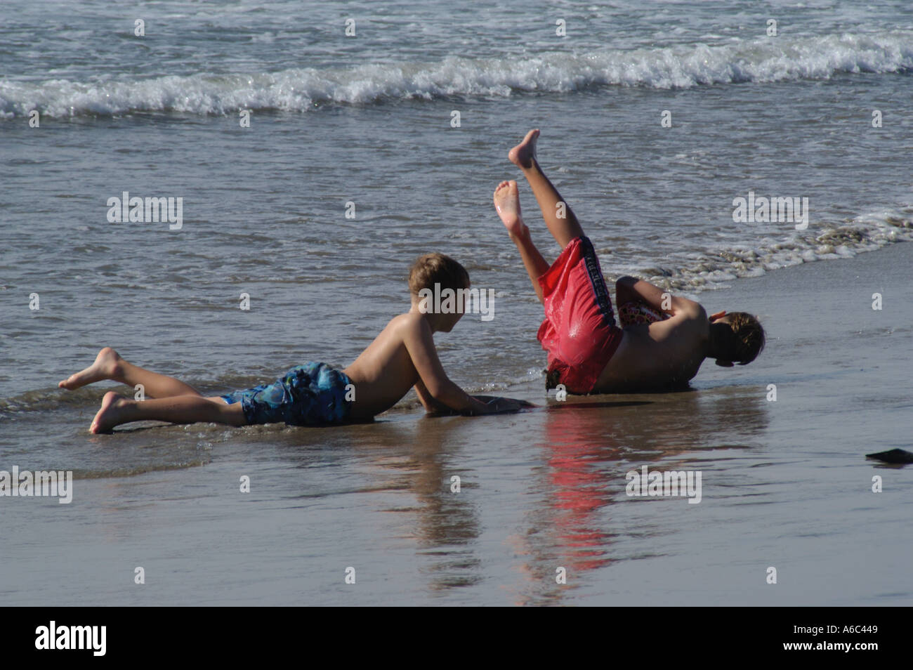 Two young boys playing in the sea Stock Photo - Alamy