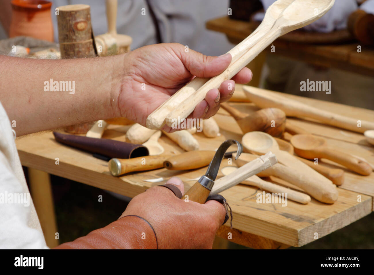 craftsmans hands holding wooden spoons and woodcarving tool Stock Photo ...