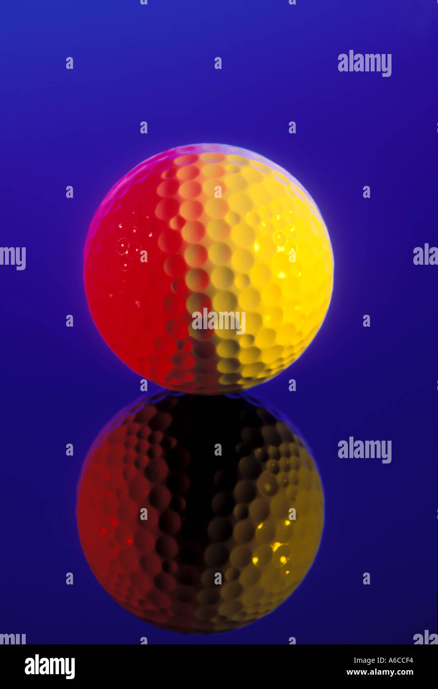 Golf Ball Yellow and Red with a Blue Background Stock Photo - Alamy