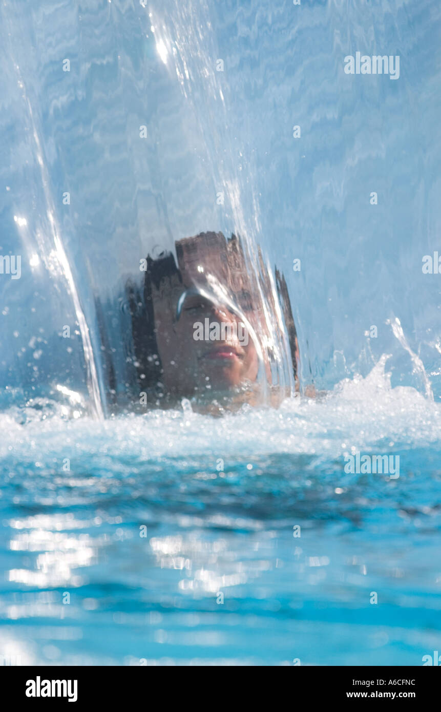 Boy Lying under Fountain in Swimming Pool Stock Photo - Alamy
