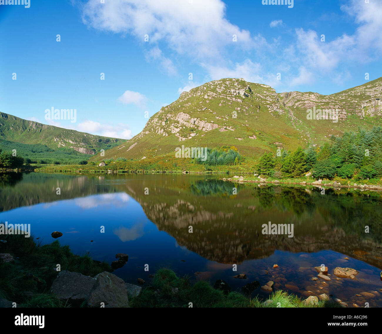 steep sided mountain reflected on a fresh water lake Stock Photo - Alamy