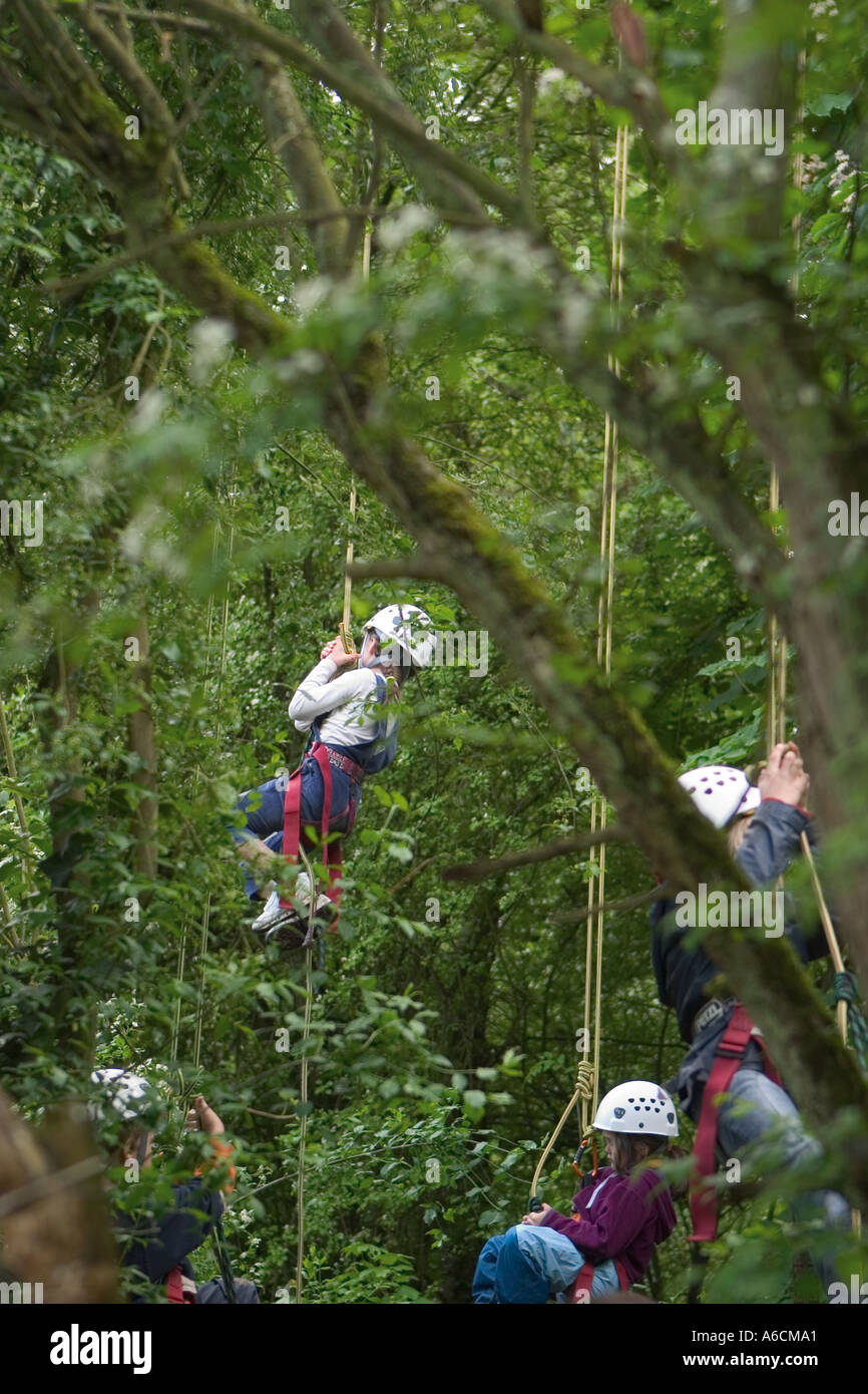 Young children prepare for a tree climbing exercise at an outdoor event ...