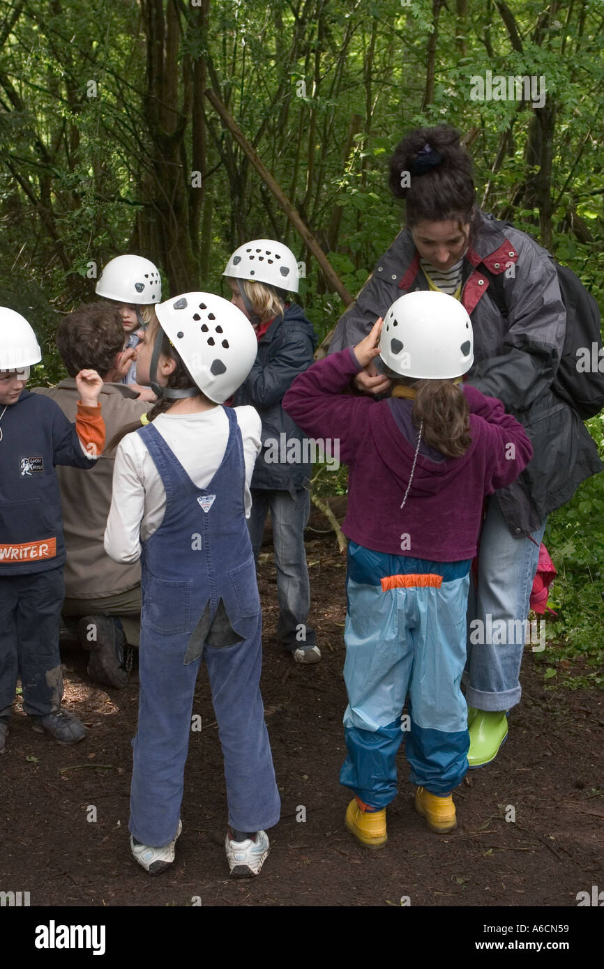 Young children prepare for a tree climbing exercise at an outdoor event ...