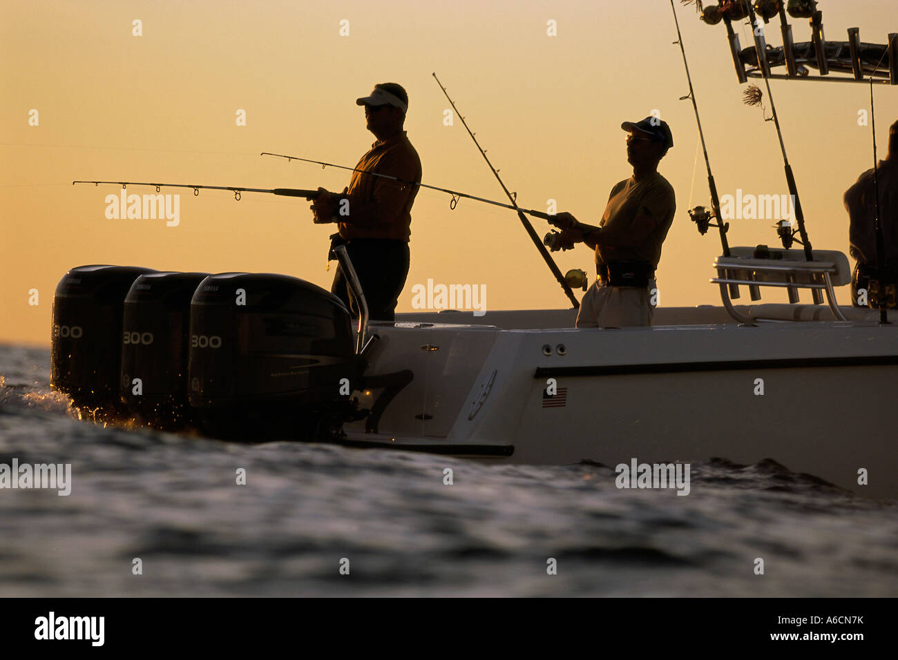Two people fishing on a boat Stock Photo - Alamy