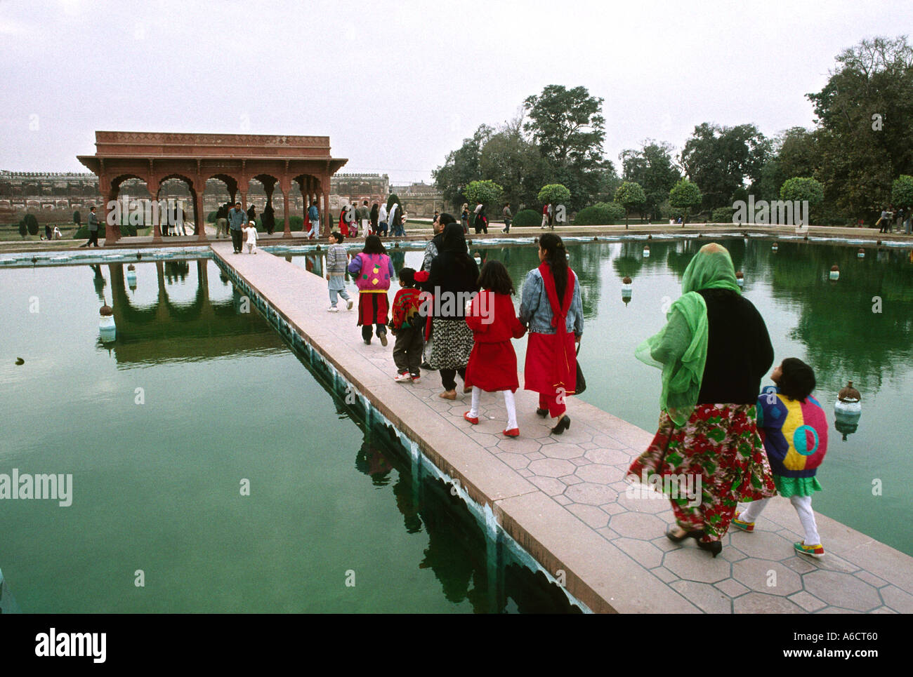 Pakistan Punjab Lahore Shalimar Gardens visitors walking across lake on ...