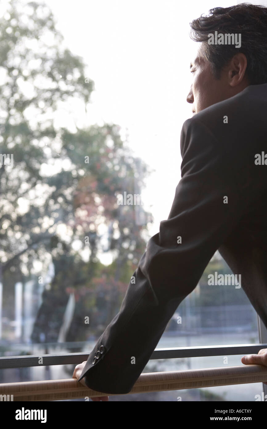 Businessman standing window looking distance hi-res stock photography ...