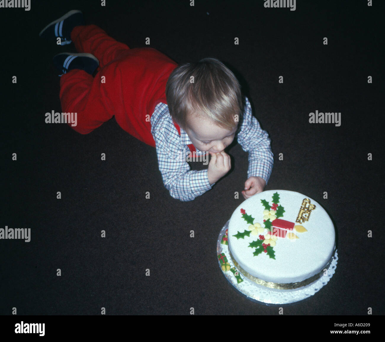 Christmas cake and young boy sampling icing Stock Photo - Alamy