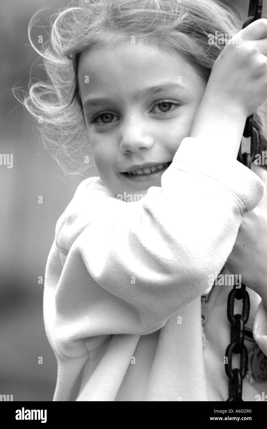 Young girl holding onto swing chain black and white Stock Photo - Alamy