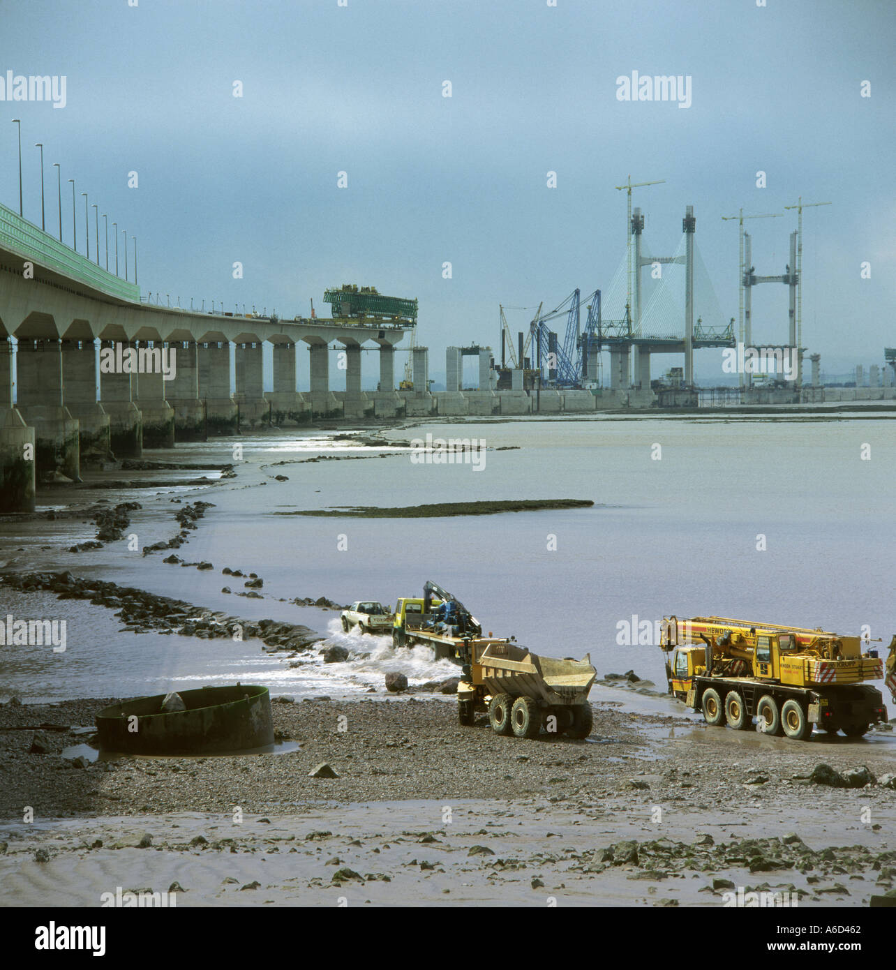 Contractors vehicles driving through river at low tide with ...