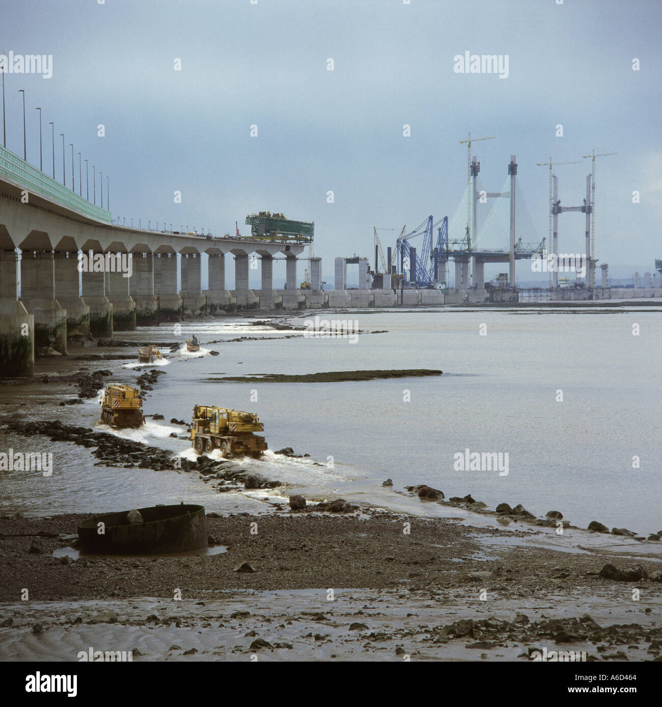 Contractors vehicles driving through river at low tide with ...