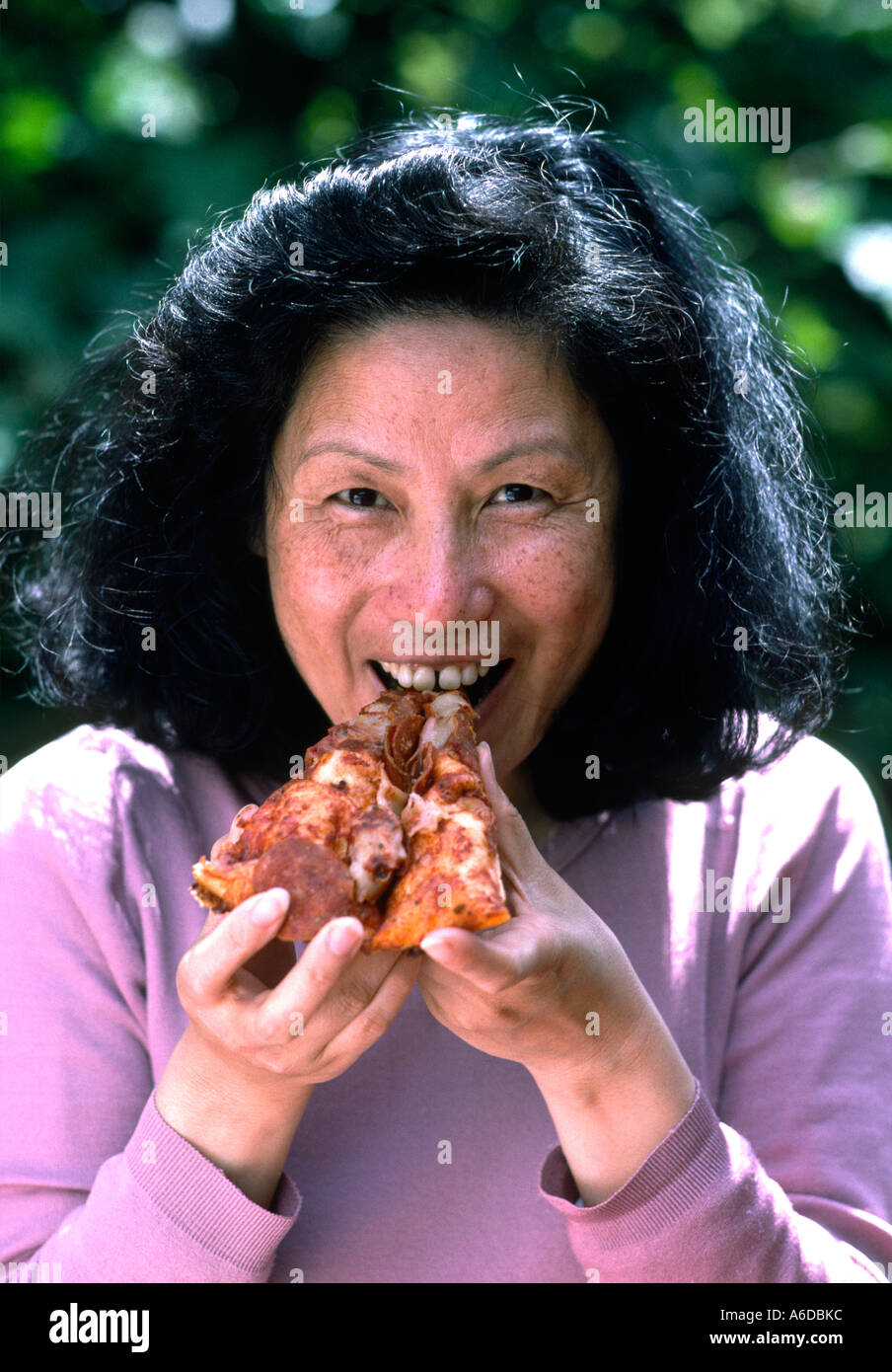 Chinese woman eating pizza slice Stock Photo - Alamy