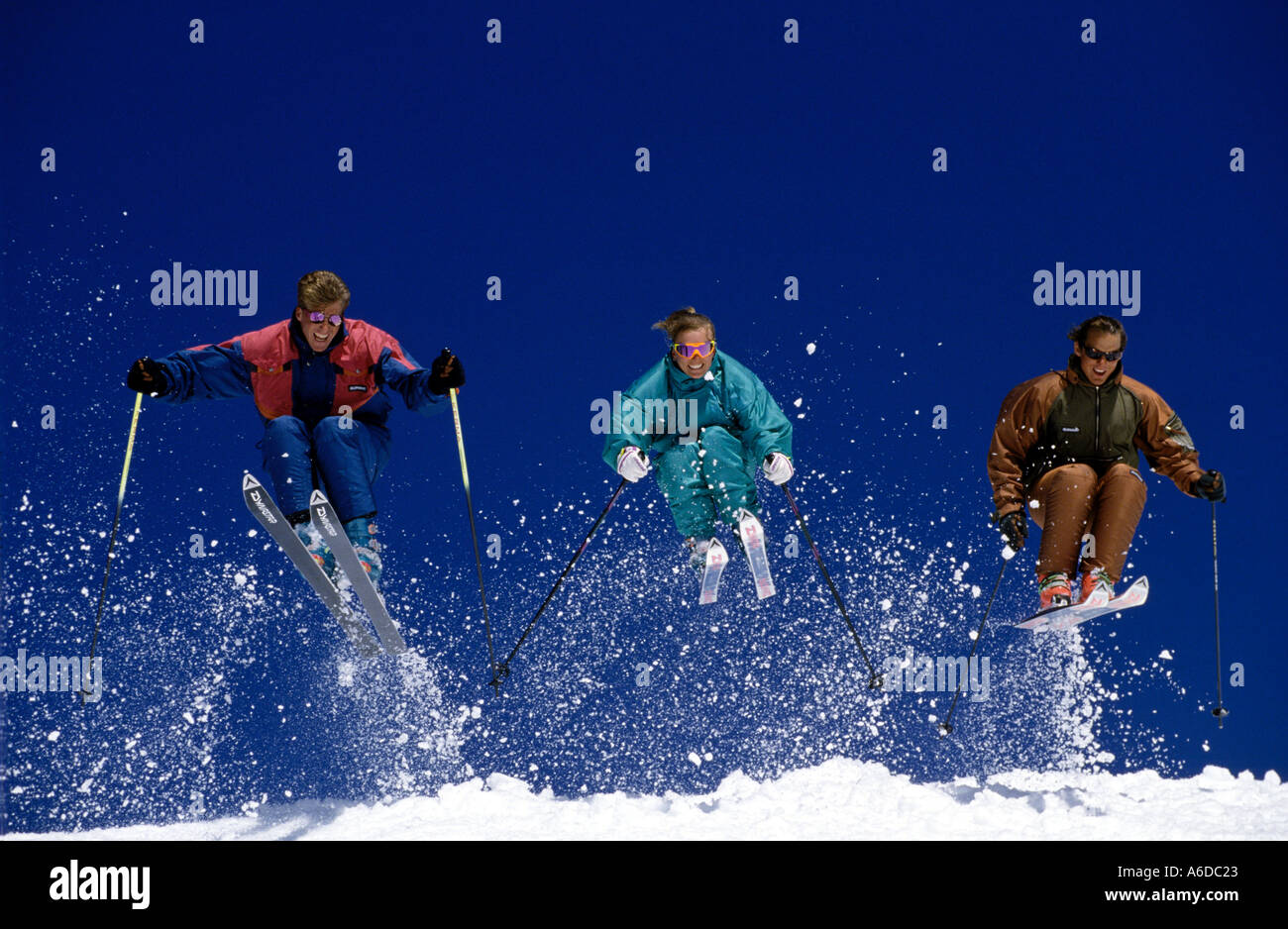 Three people jumping on skis Stock Photo - Alamy