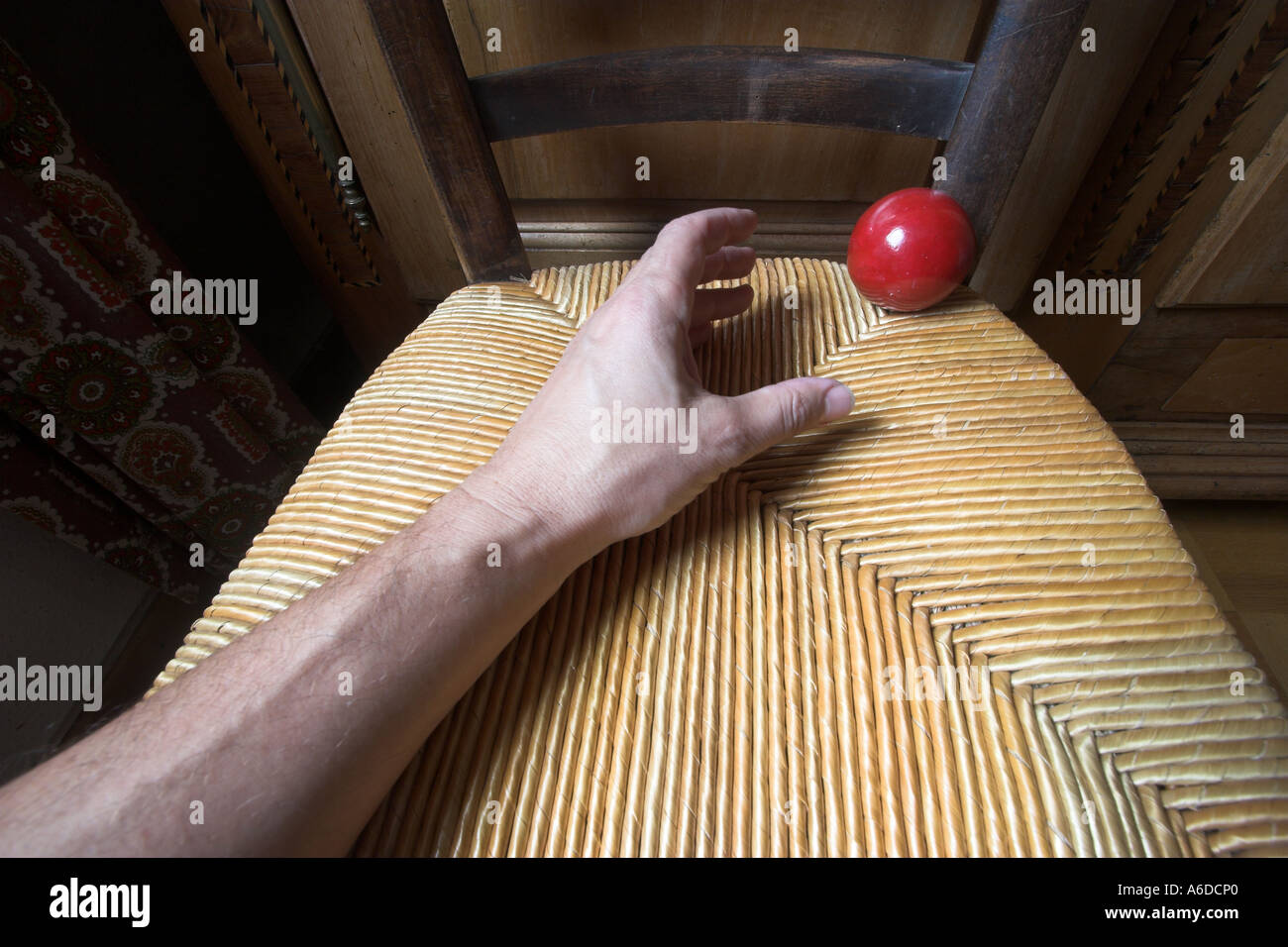 hand and arm of a man toward a red ball on a chair Stock Photo - Alamy