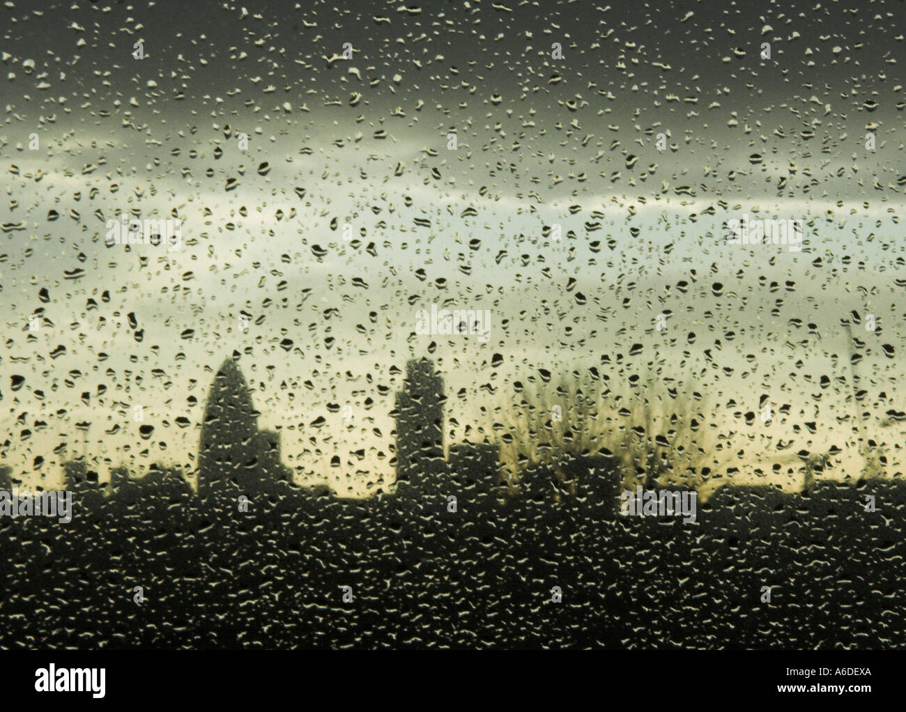 Heavy clouds over London's skyline seen through a rain covered window ...