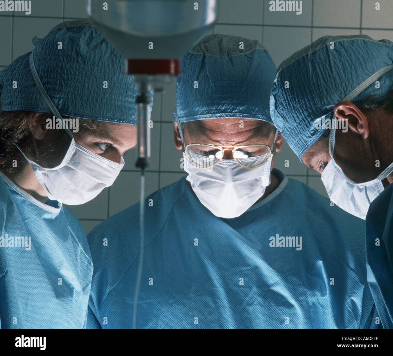 three person medical team performing surgery hospital Stock Photo - Alamy