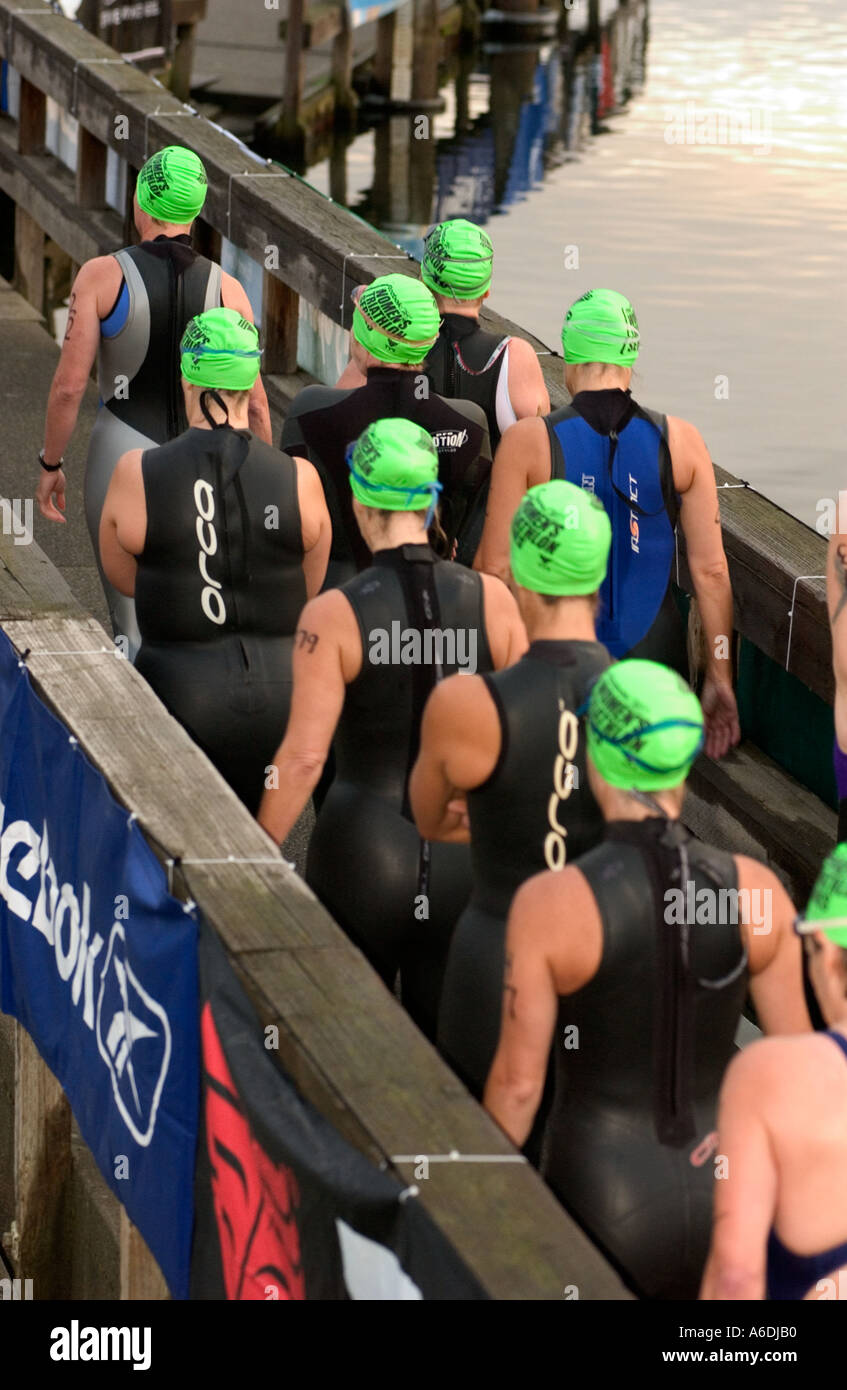 Women getting into water for swimming portion of triathlon Stock Photo ...