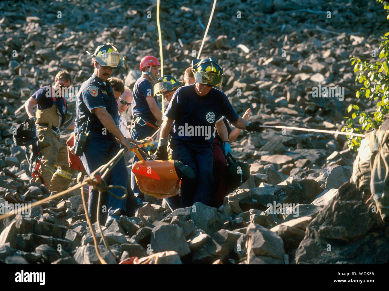 Emergency personnel Firefighters EMTs conduct a rock climbing steep ...