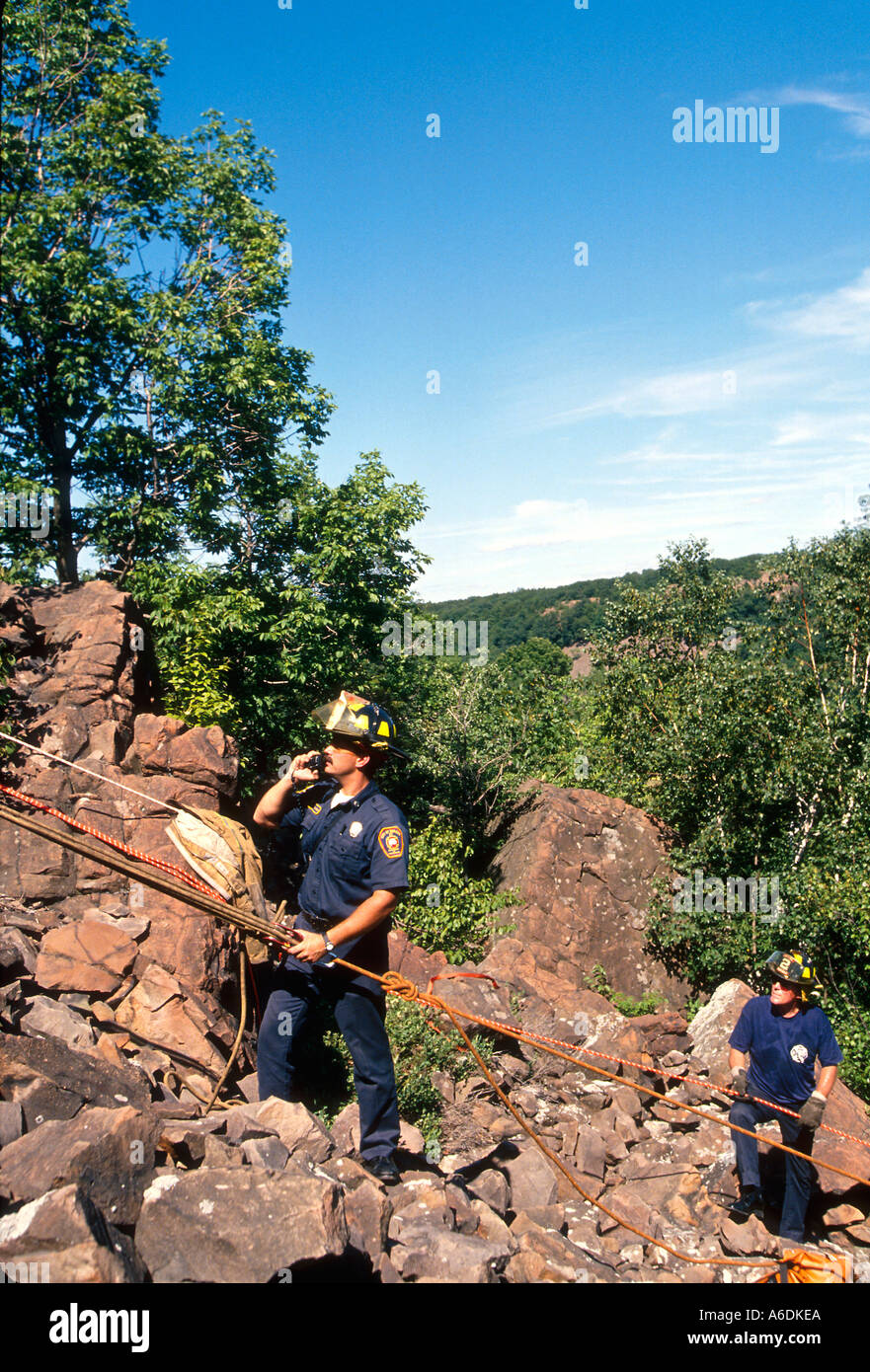 Emergency personnel Firefighters EMTs conduct a rock climbing steep ...