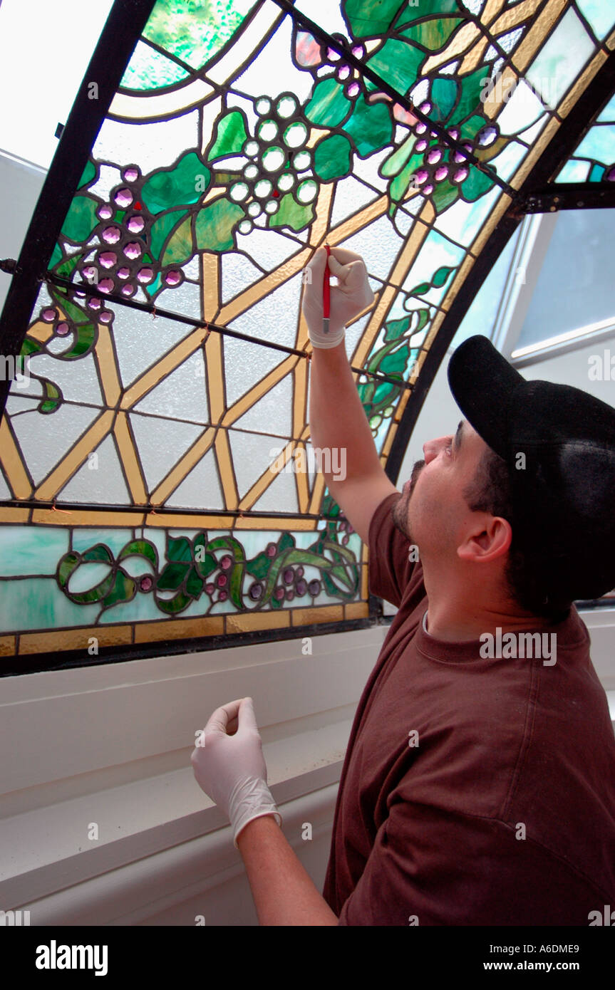 Workers install stained glass panels int eh lobby of the Carlton Hotel ...