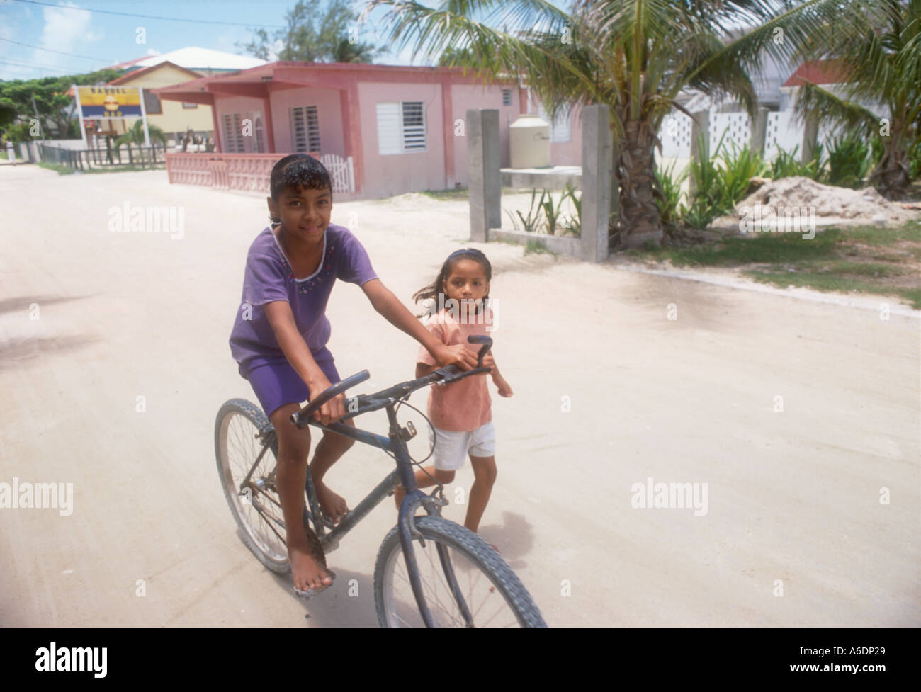 Girls traveling dirt street San Pedro Belize bike bicycle Stock Photo - Alamy