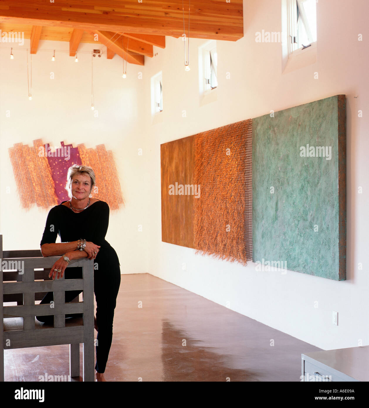 Portrait of artist Susan Venable standing in studio surrounded by ...