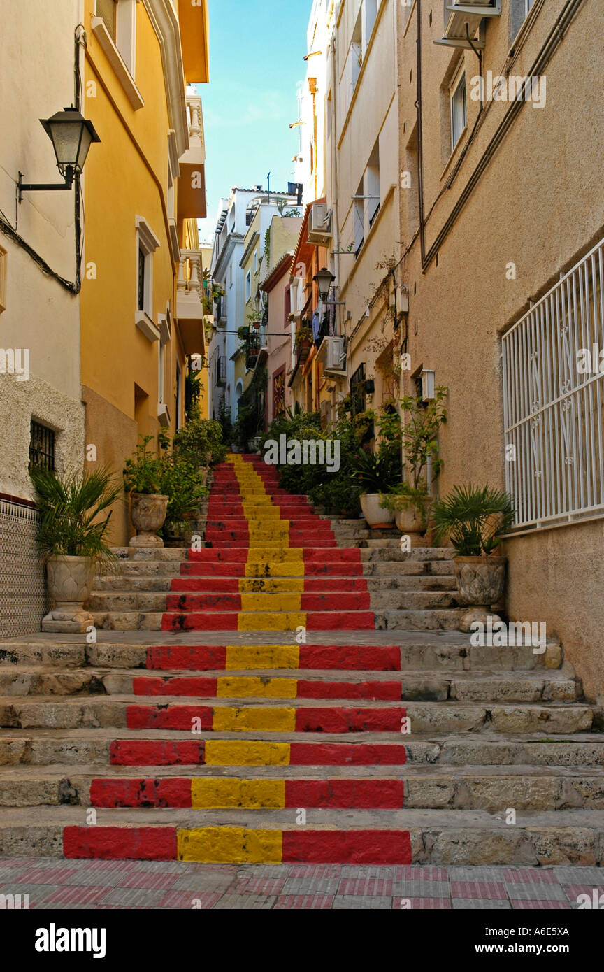 Steep lane with stairway steps in the Spanish national colors, old part ...