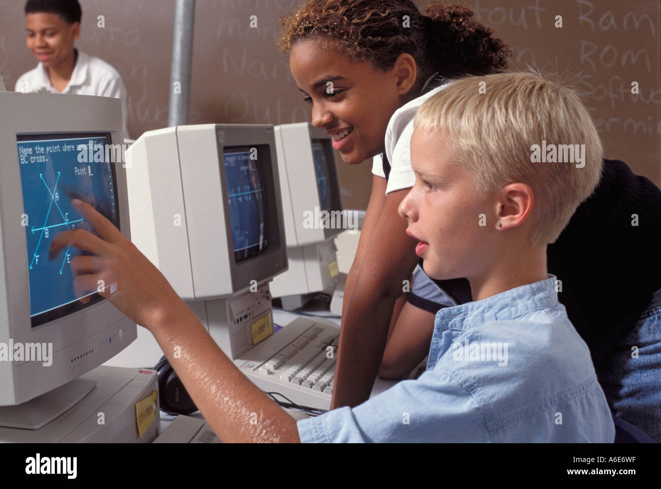 African American and Caucasian students in middle school computer room ...