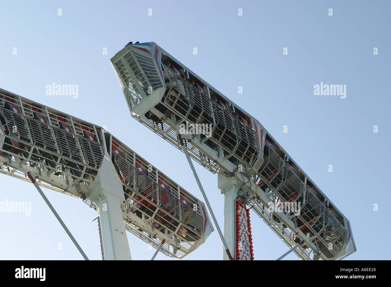 Twin caged fun fair rides swing past each other vertically Brighton ...