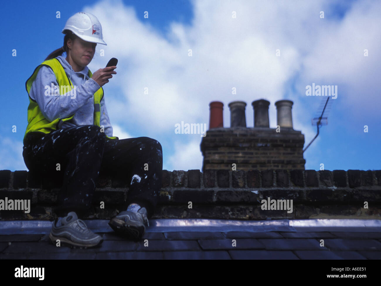 Female construction worker using mobile phone on rooftop Stock Photo ...
