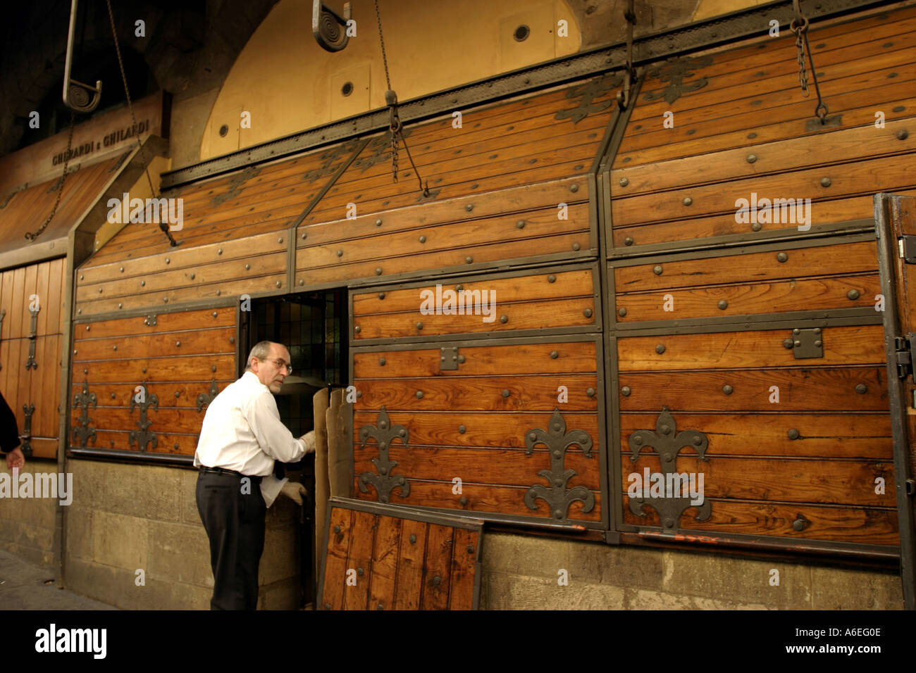 europe italy tuscany florence a shopkeeper closing the shutters of his ...