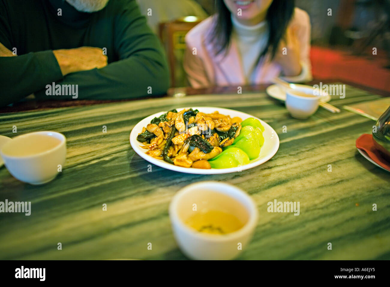 CHINA BEIJING Diners eating with chopsticks traditional Chinese dish of ...