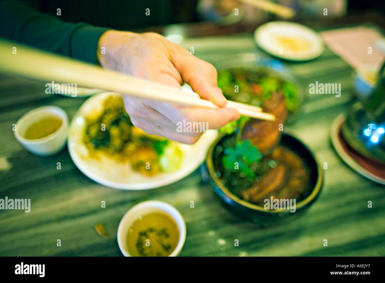 CHINA BEIJING Diners eating with chopsticks traditional Chinese meal of ...