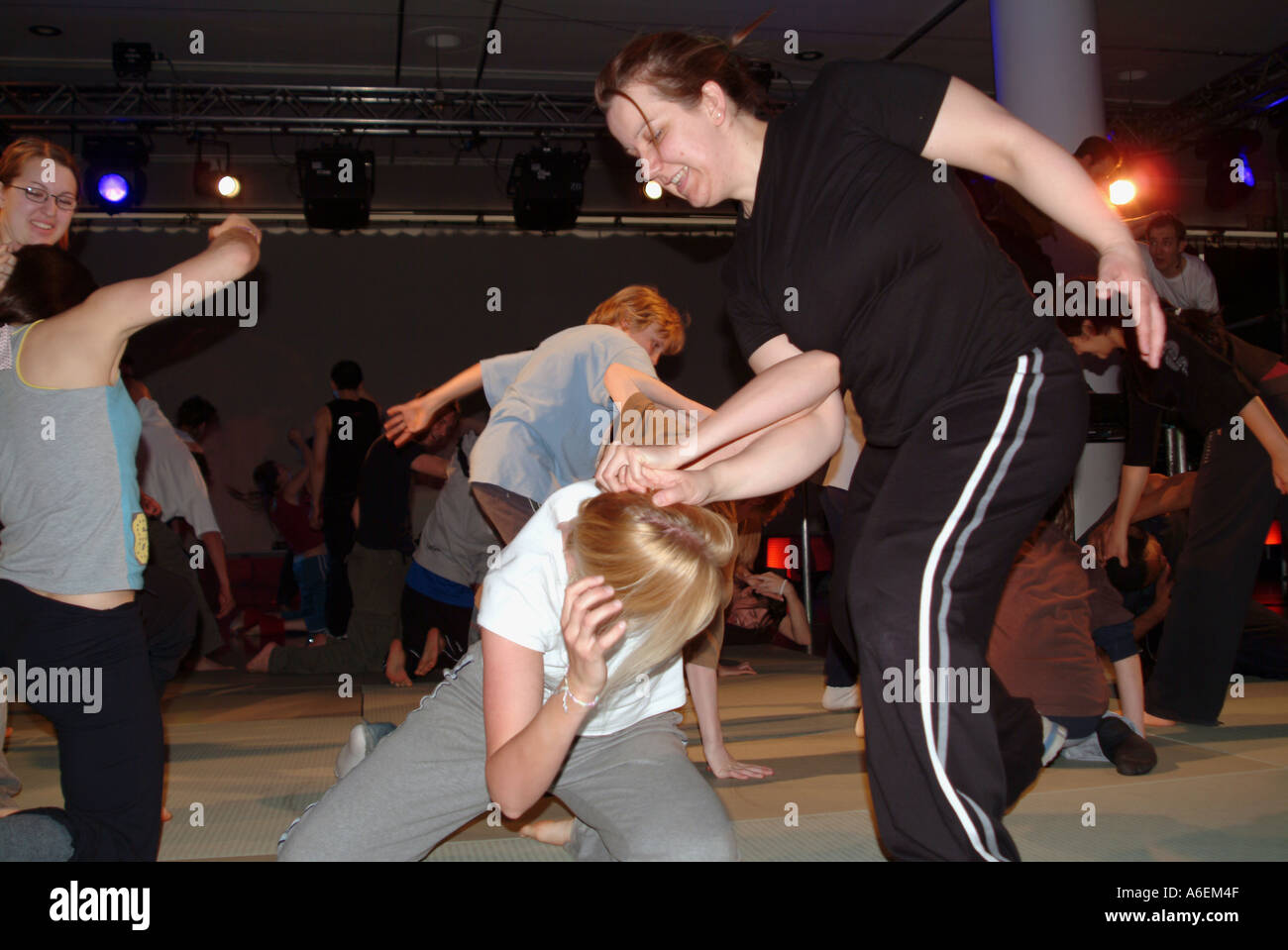 GROUP OF PEOPLE PRETENDING AND PRACTISING FIGHTING HITING EACH OTHER AS ...