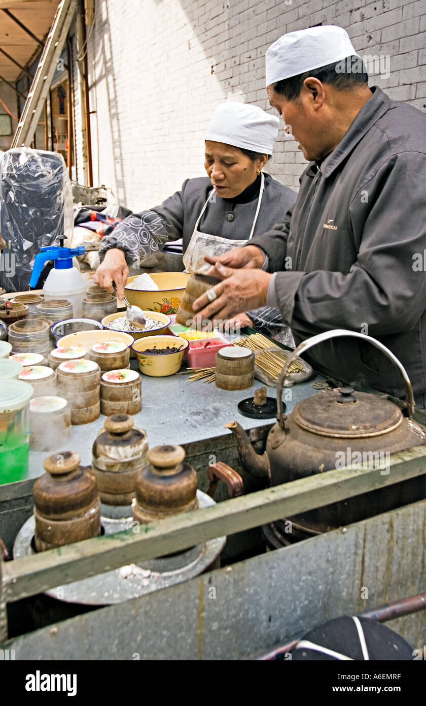 CHINA XI'AN Street vendors preparing decorated sweet cakes to sell on ...