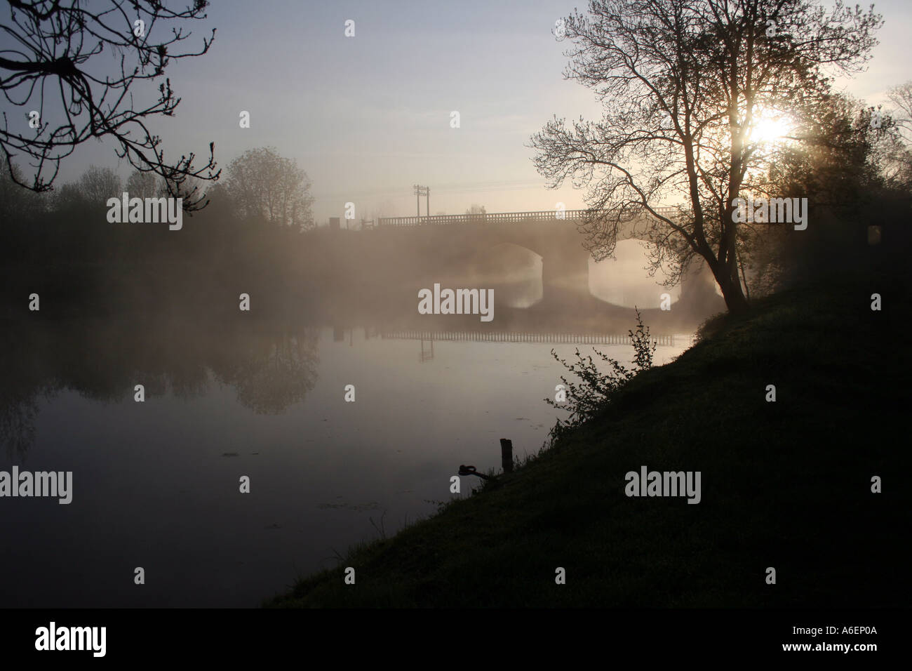 Mist and sun rising over the water of the river Vendee France early ...