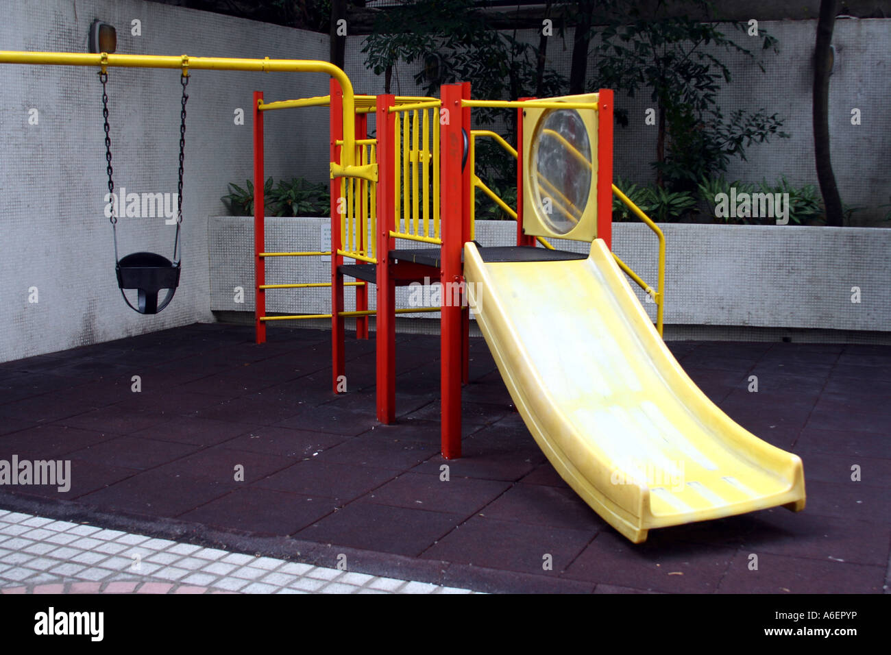 Playground slide and swing in yellow and red Stock Photo - Alamy