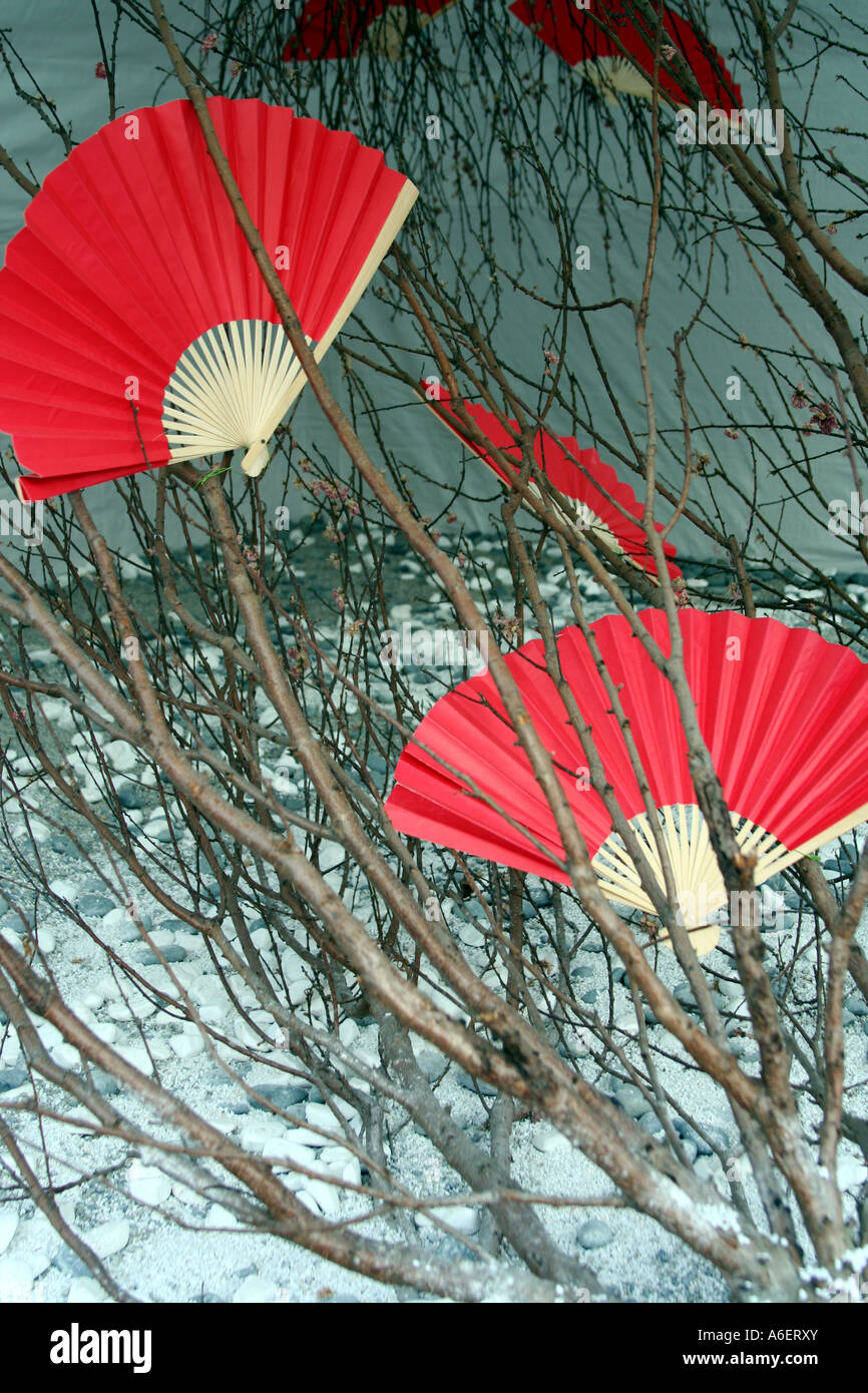 Oriental gardening: red fans in tree branches Stock Photo - Alamy