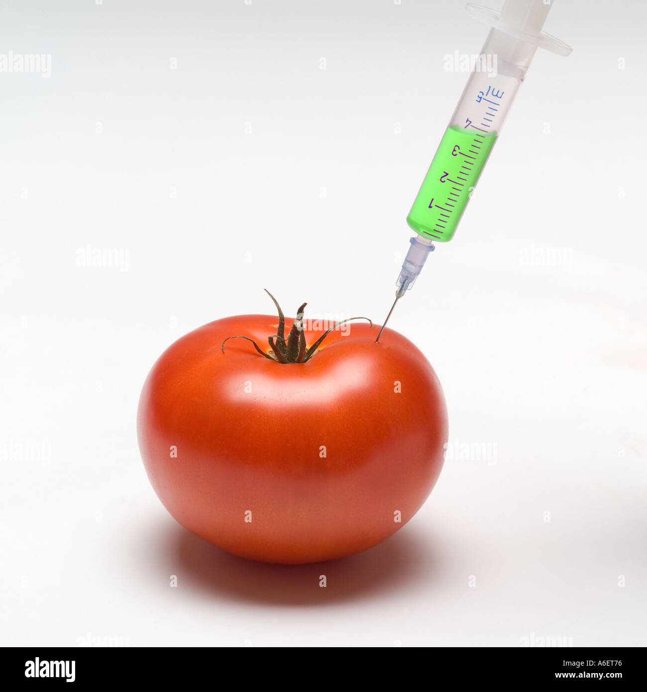 RED TOMATO BEING INJECTED A GREEN LIQUID BY AN HYPODERMIC NEEDLE Stock ...