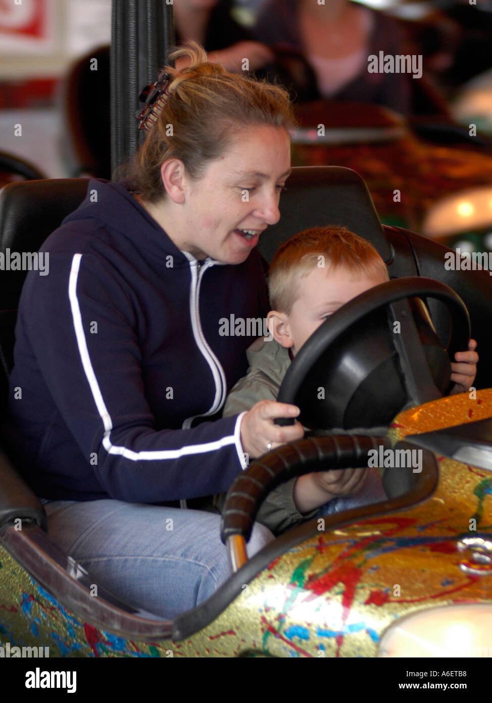 Mother and son enjoying a ride on the Dodgems at an Amusement Park ...