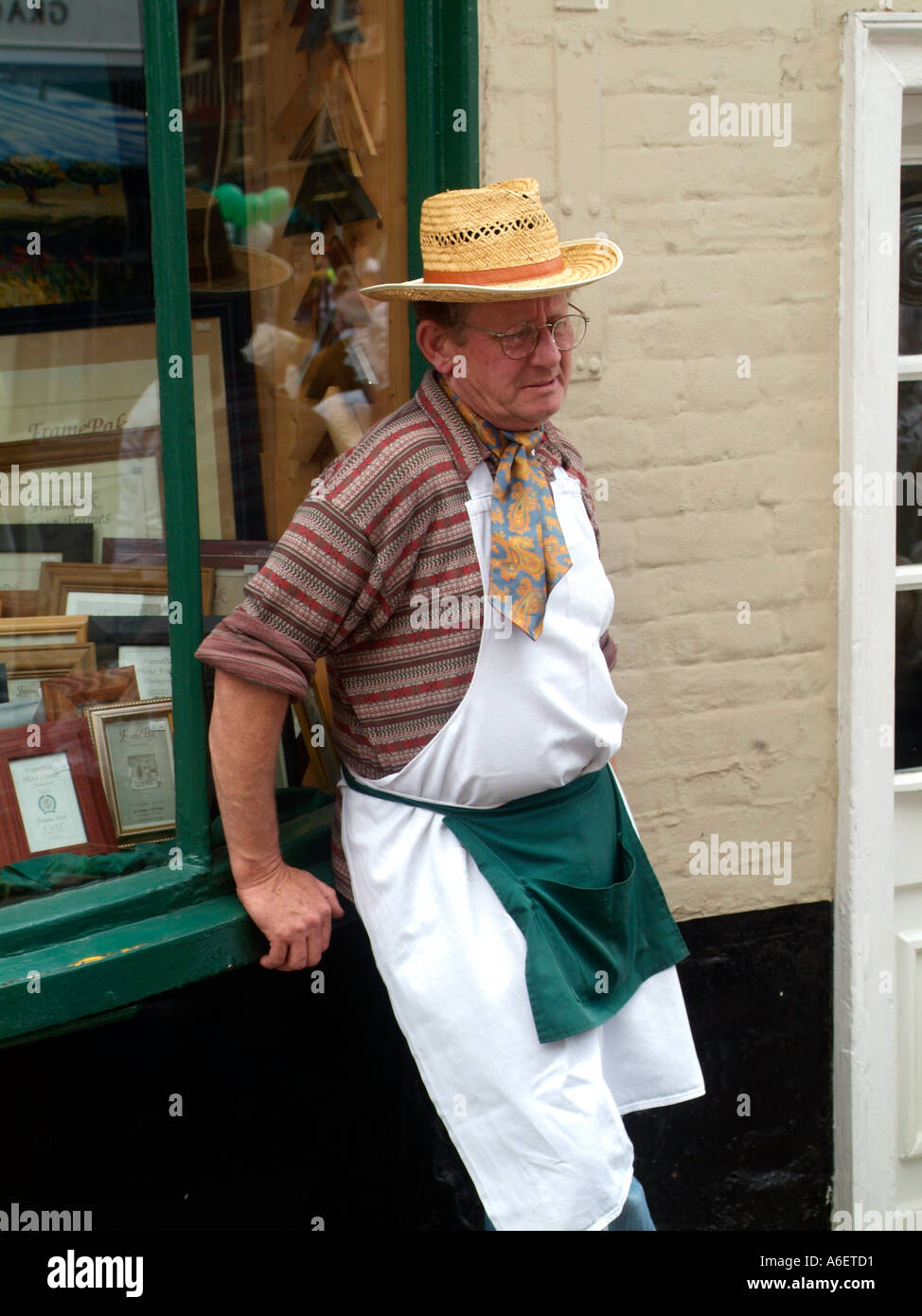 Market stall holder wearing a butchers apron and money bag around his ...
